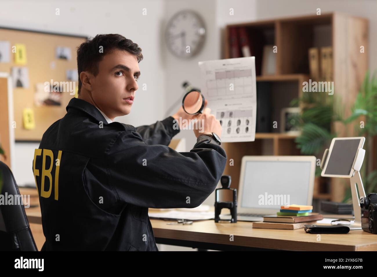 Male FBI agent studying fingerprints at table in office Stock Photo - Alamy