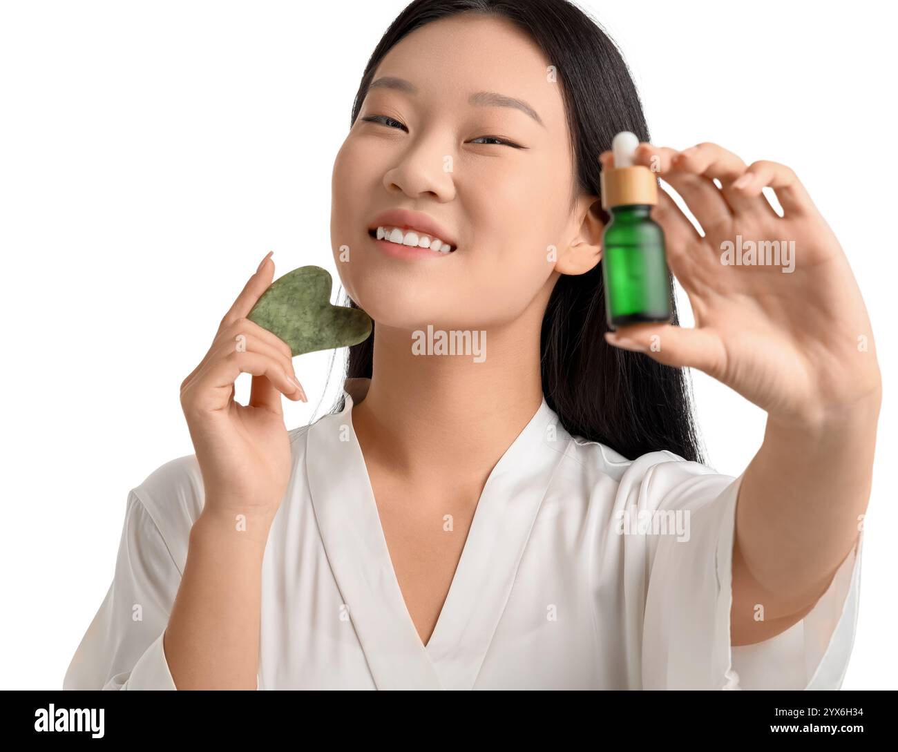 Young Asian woman with gua sha and oil on white background, closeup Stock Photo - Alamy