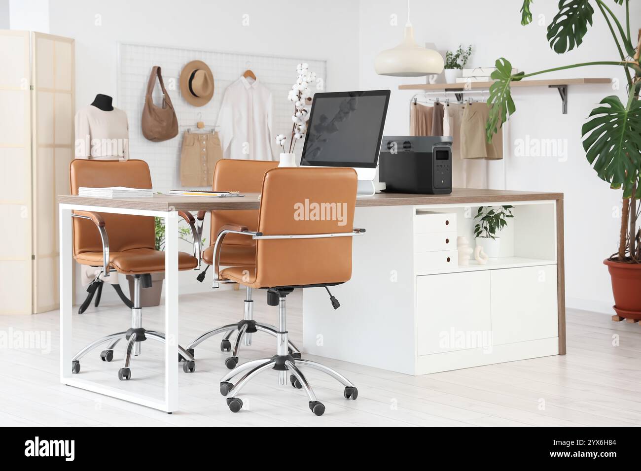 Interior of clothing store office with workplace and portable power ...