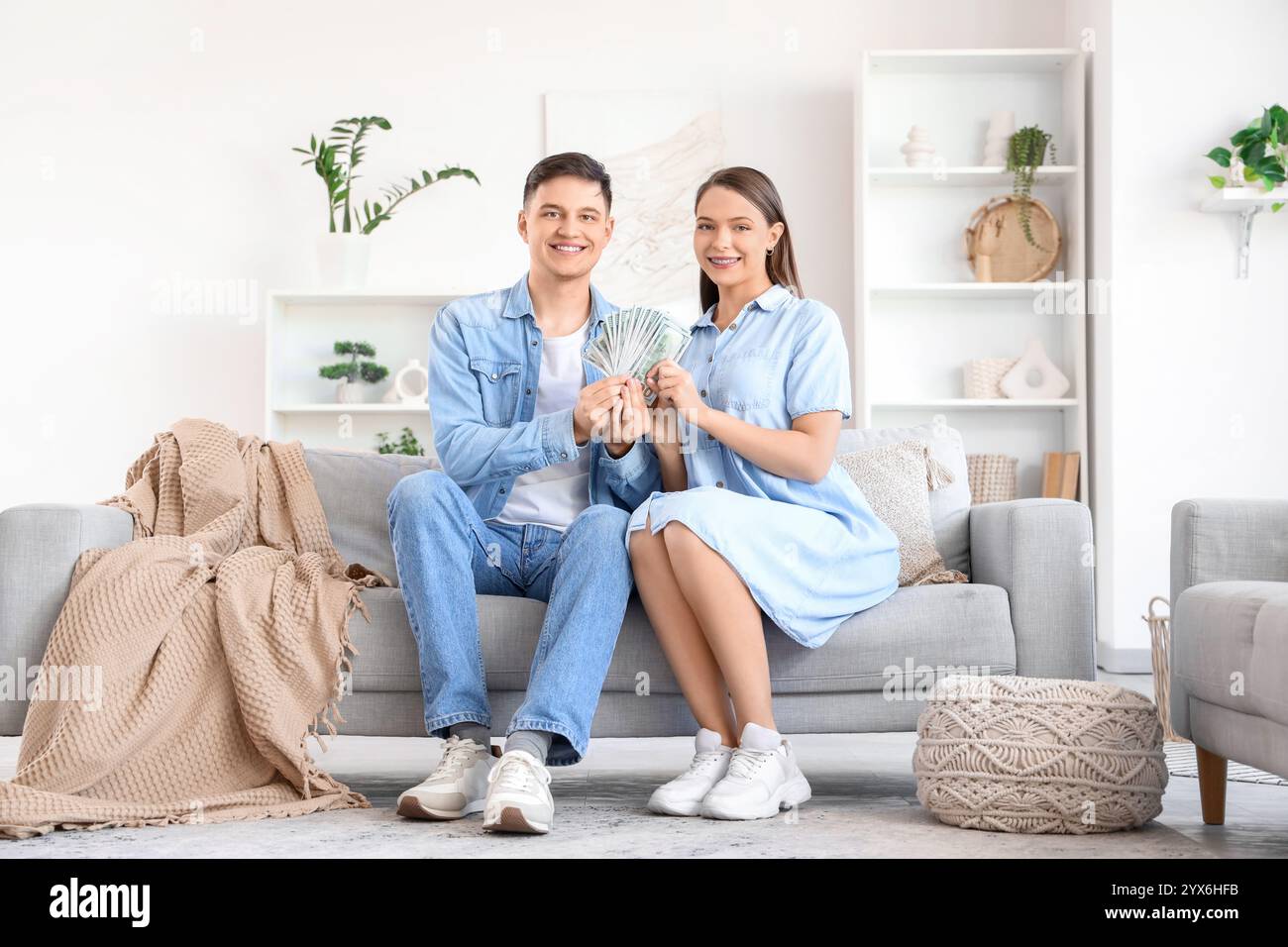 Young rich couple sofa money hi-res stock photography and images - Alamy