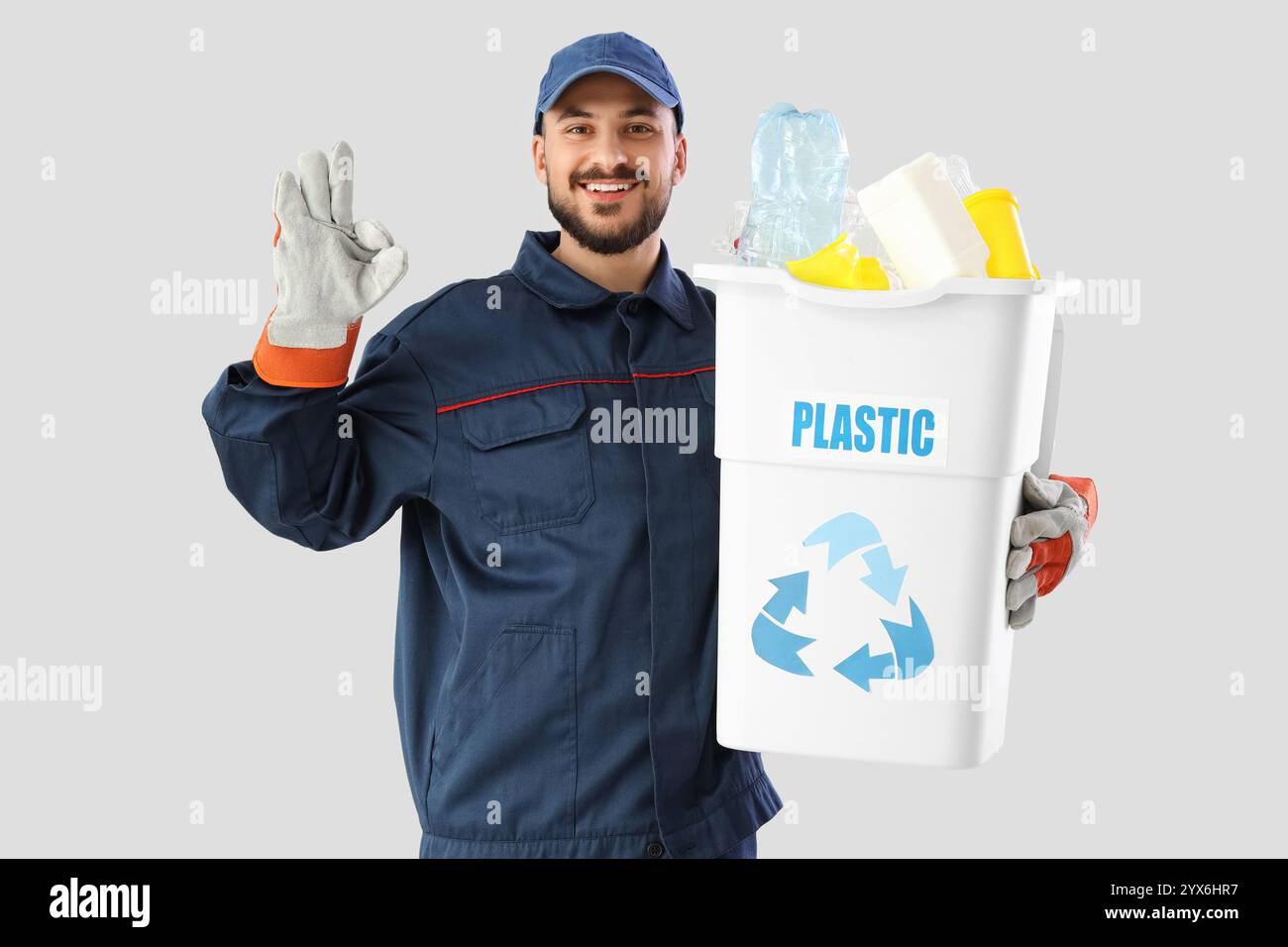 Male scavenger holding recycle trash bin with plastic and showing OK on ...