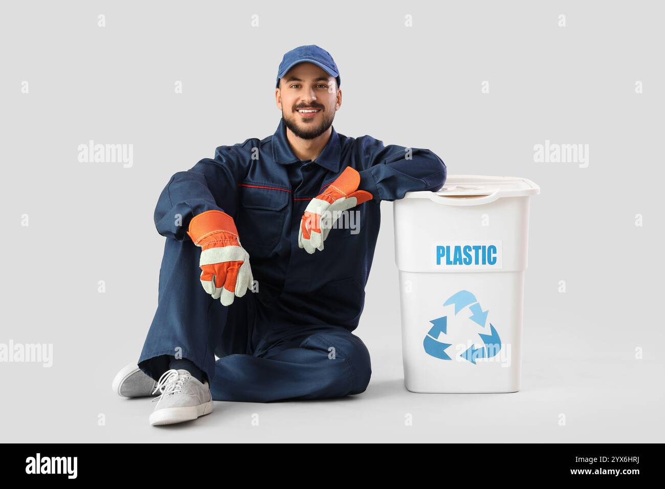 Male scavenger with recycle trash bin for plastic sitting on light ...