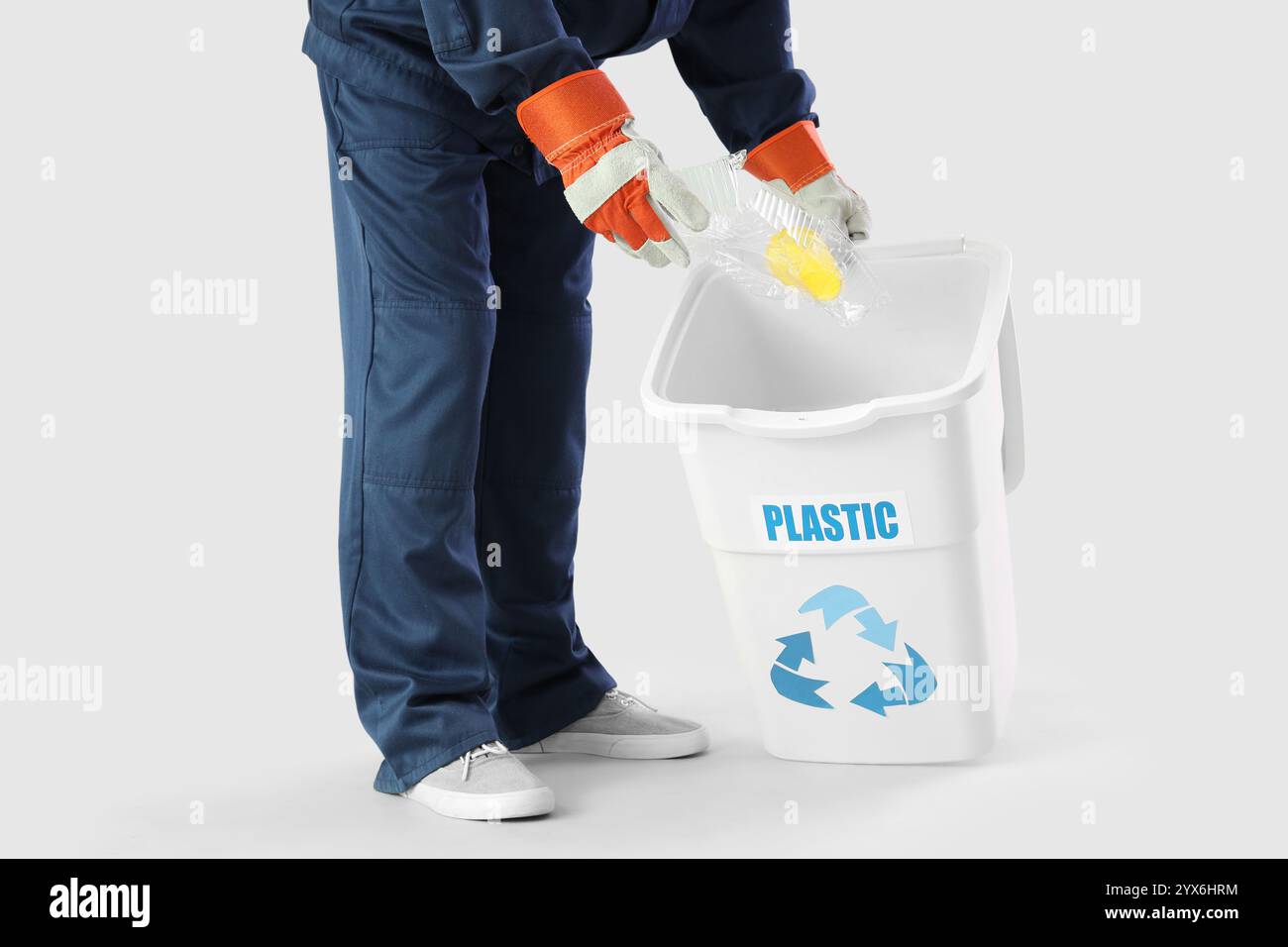 Male scavenger throwing plastic into recycle trash bin on light ...