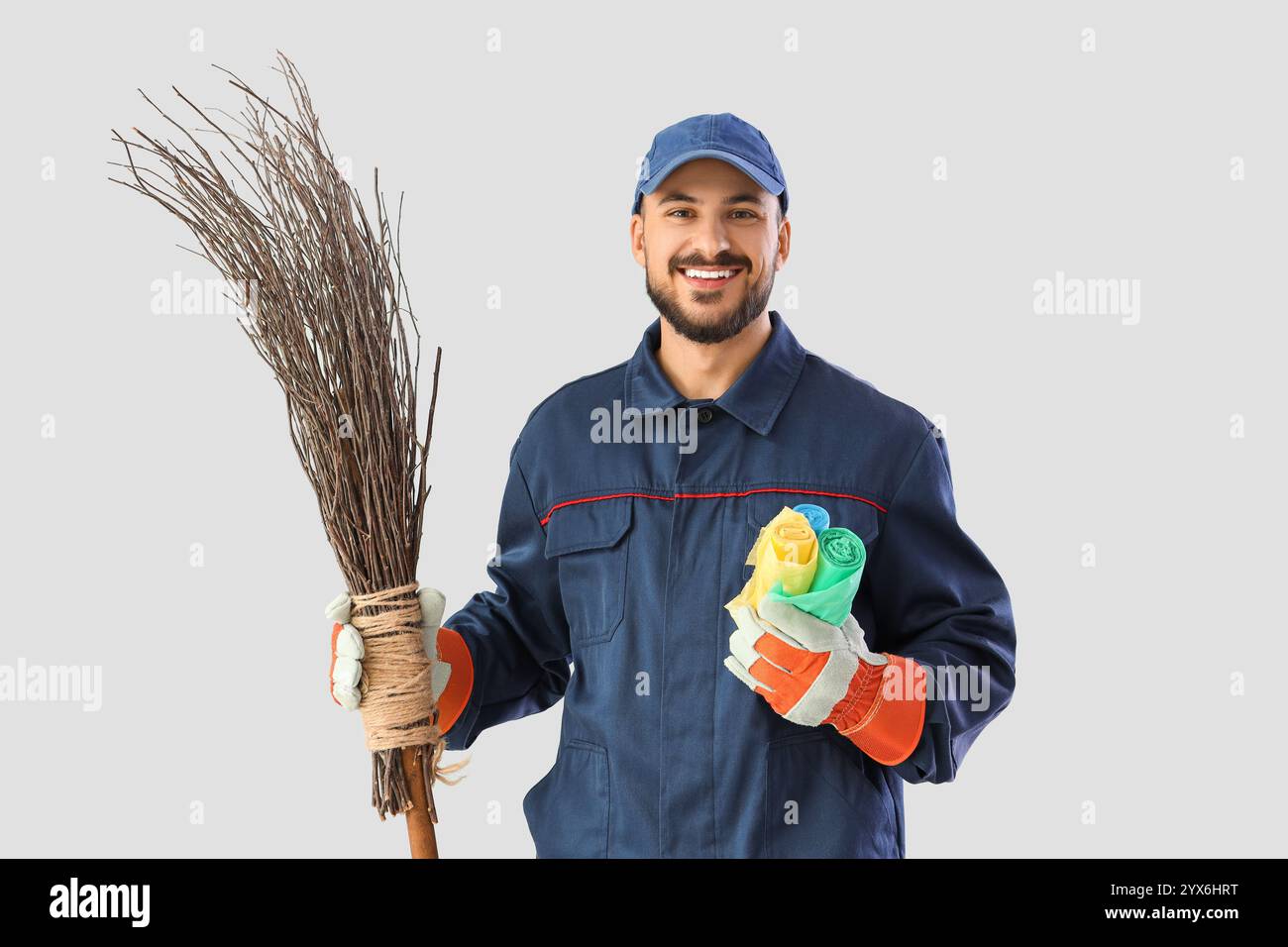 Male scavenger with garbage bags and broom on light background Stock ...