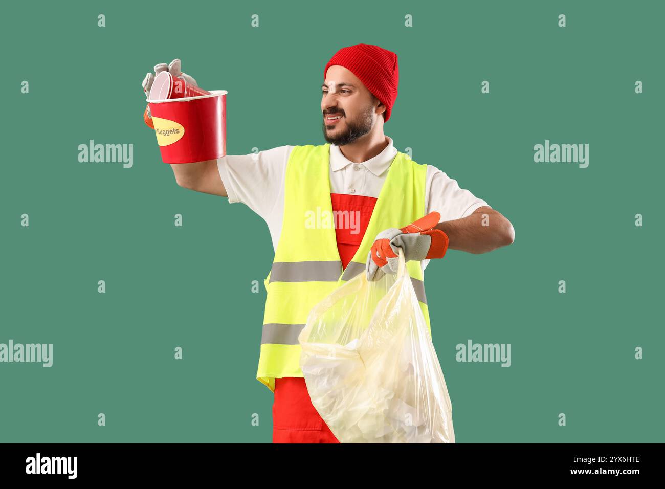 Male scavenger throwing food containers into garbage bag on green ...