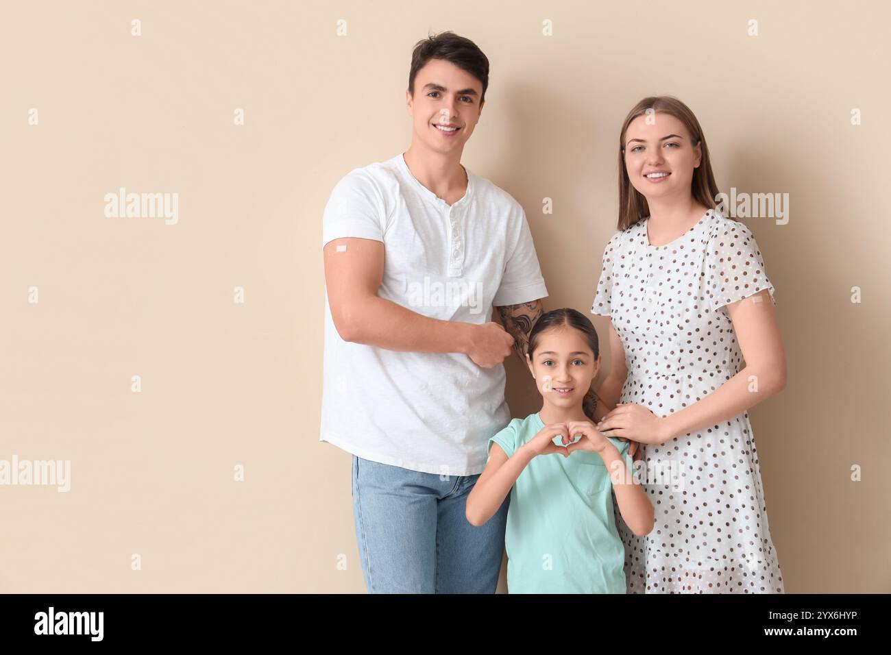 Parents and their daughter with medical patches after vaccination ...
