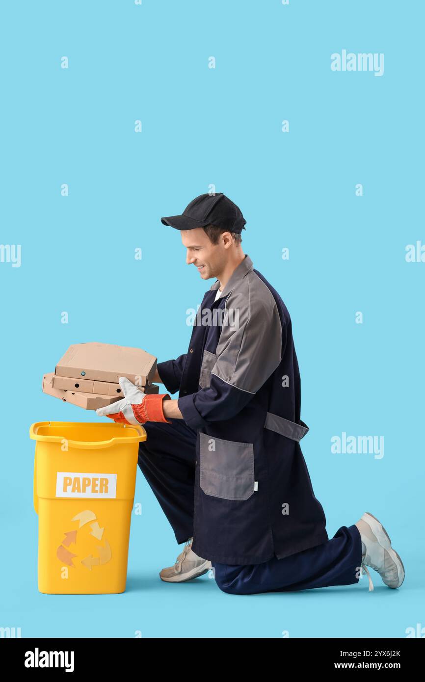 Male scavenger throwing pizza boxes into trash bin on blue background ...