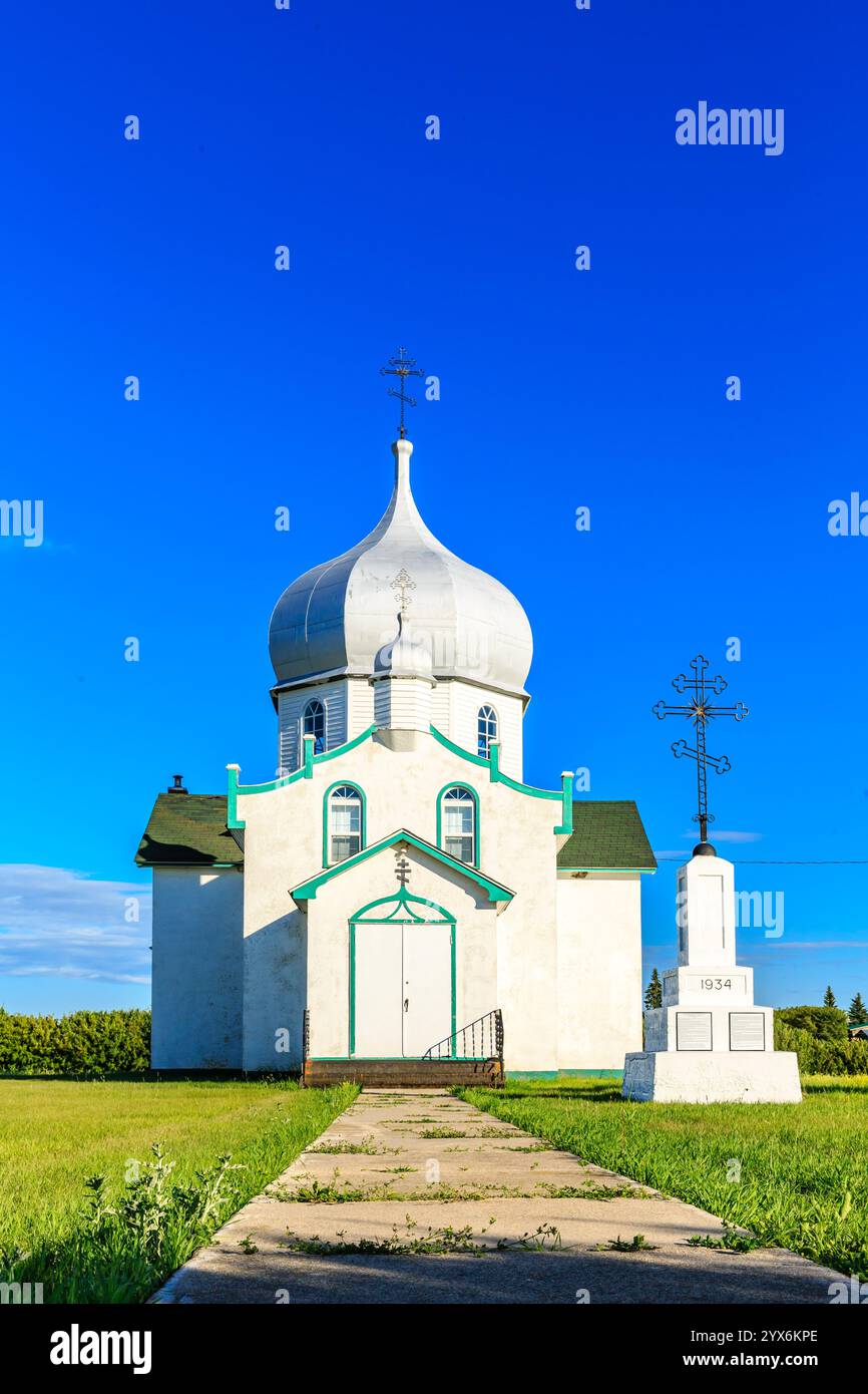 A small white church with a green roof and a cross on top. The church ...