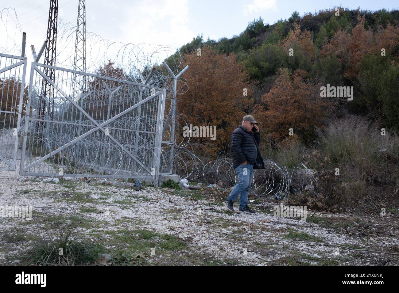 Syrian refugee seen talking on the phone in front of the Syrian border fence at Yaylada?? border ...