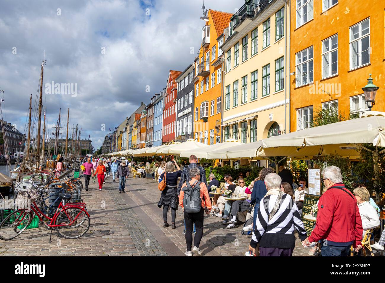 Visitors enjoy lunch at one of the many waterfront restaurants and cafes in the Nyhavn district ...