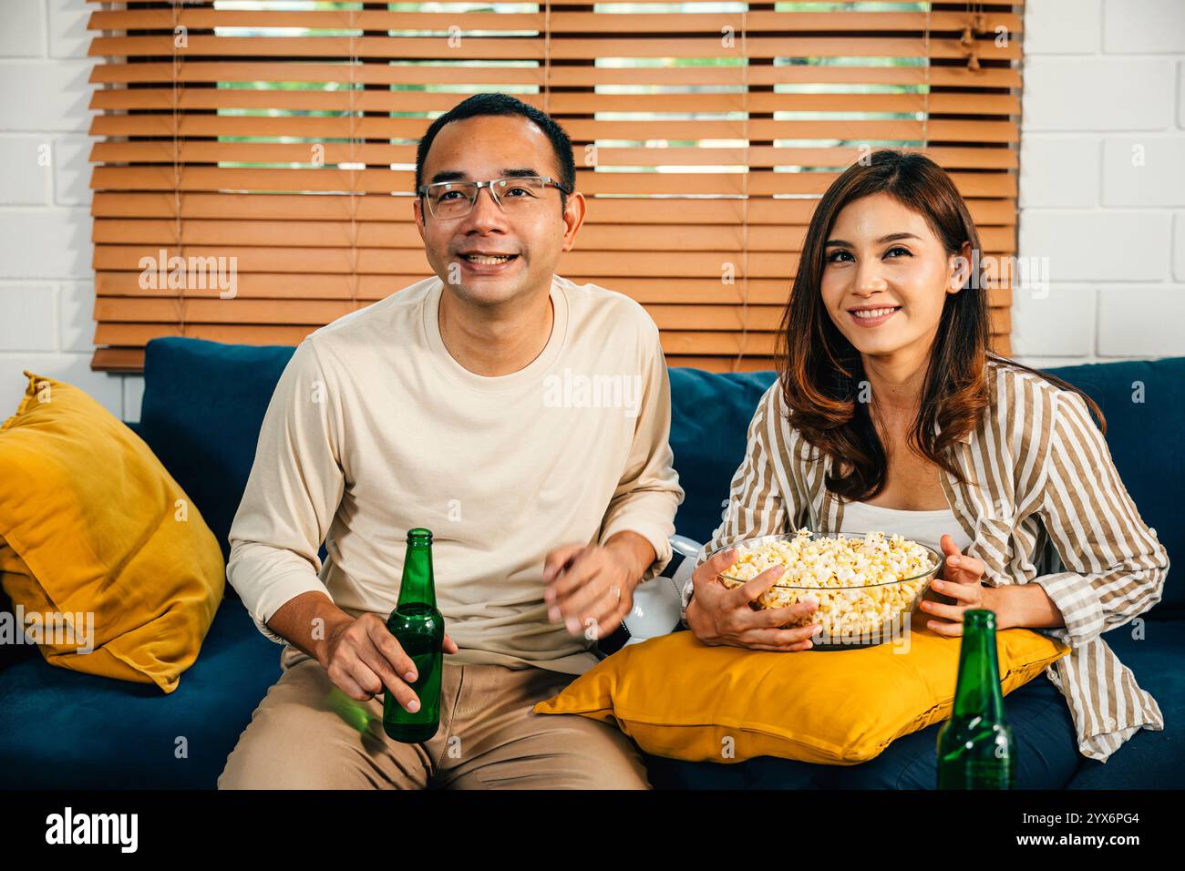Excited young couple celebrates victory while watching TV their cheers ...