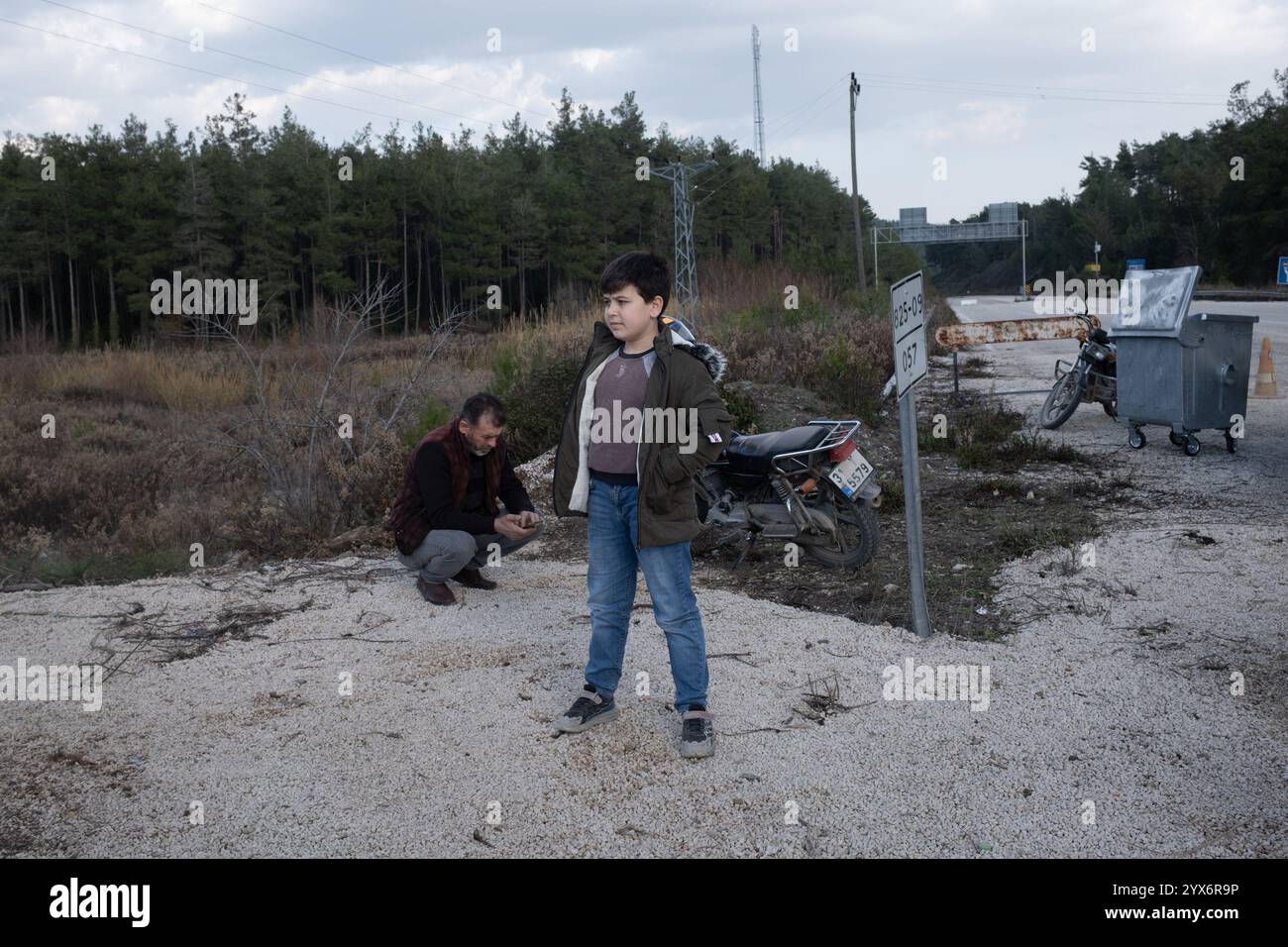 A Syrian man and his son wait at the border. On December 8, 2024, Islamist-led opposition forces ...