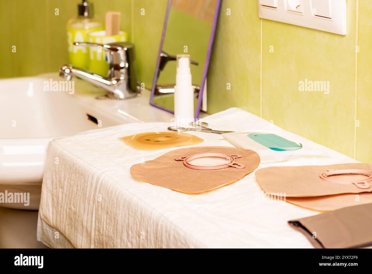 Preparing to change an adhesive barrier and ostomy bag in a bathroom ...