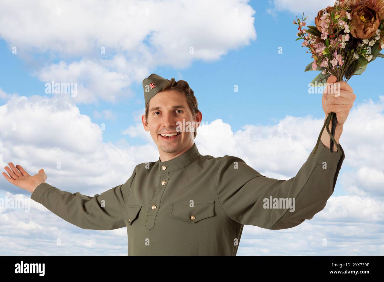 Soviet soldier in uniform of World War II holding a bunch of flowers on ...