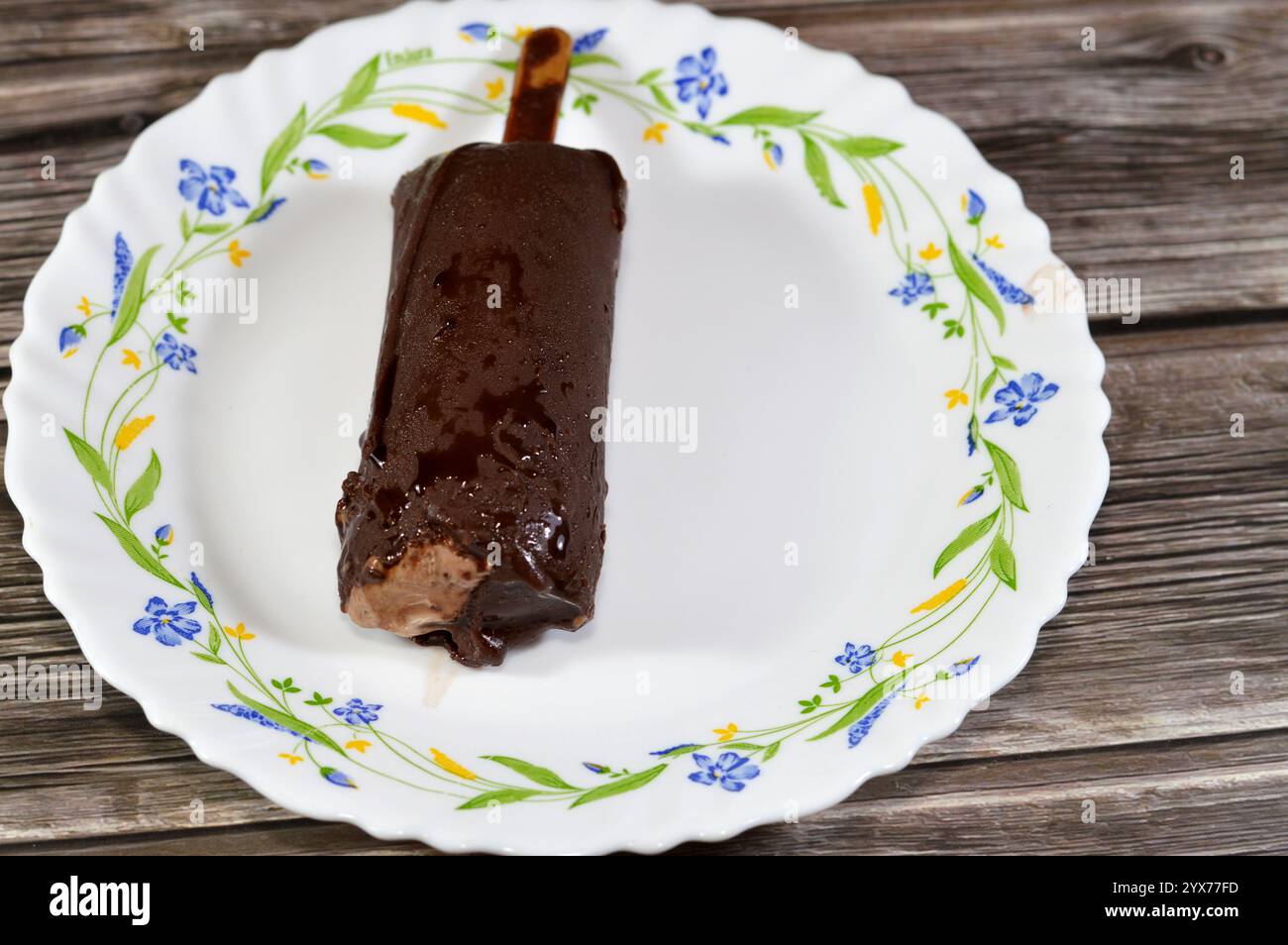 Chocolate ice cream stick coated and covered with a layer of plain ...