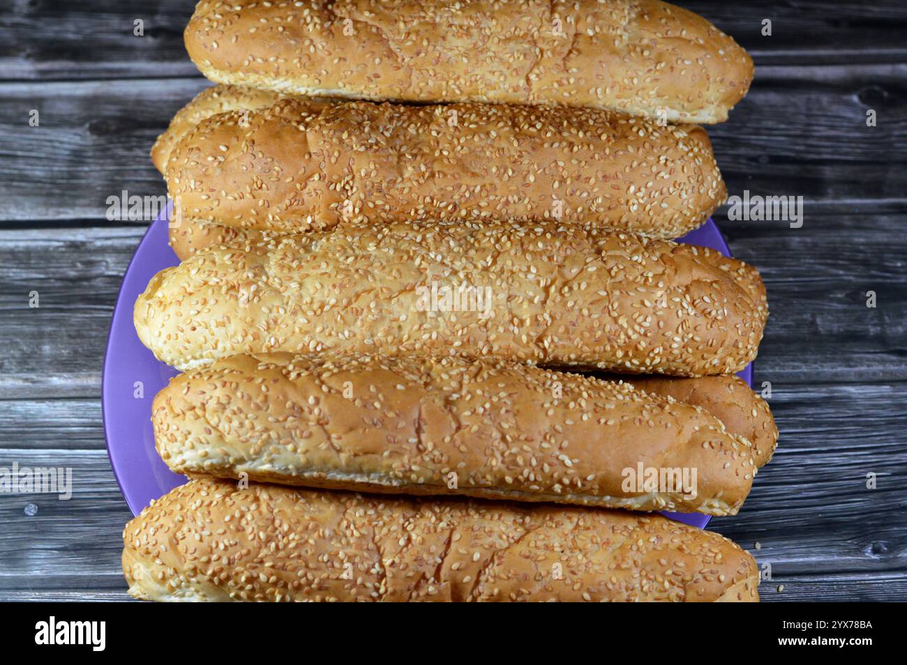 Pile of long sesame buns bread, a fresh baked loaf of bread French Fino ...