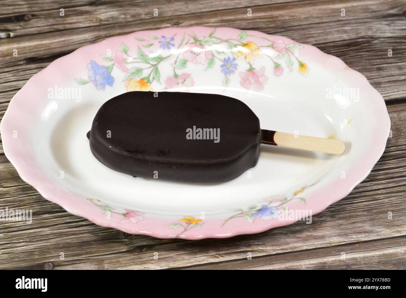 A chocolate ice cream stick coated and covered with a layer of plain ...