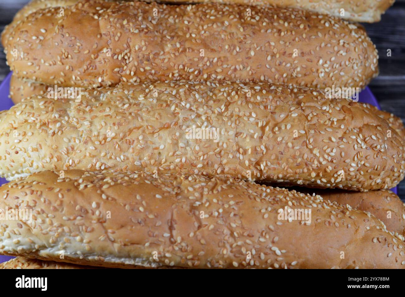 Pile of long sesame buns bread, a fresh baked loaf of bread French Fino ...