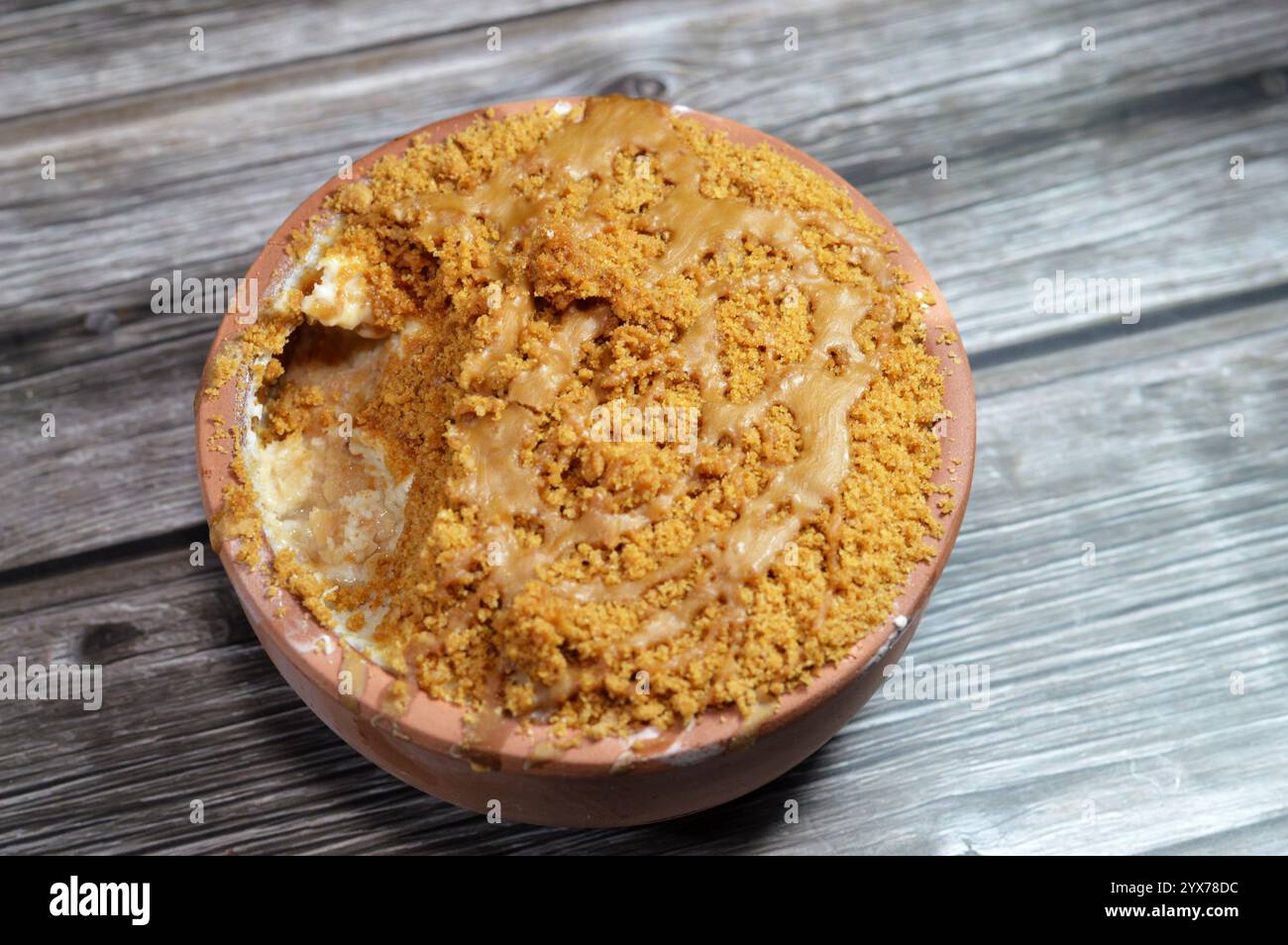 Egyptian bread pudding topped with biscuits butter spread, milk in bowl ...