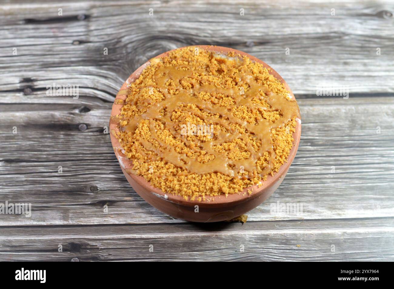 Egyptian bread pudding topped with biscuits butter spread, milk in bowl ...
