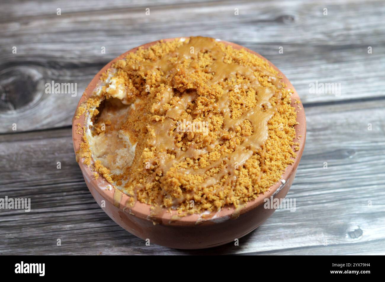 Egyptian bread pudding topped with biscuits butter spread, milk in bowl ...