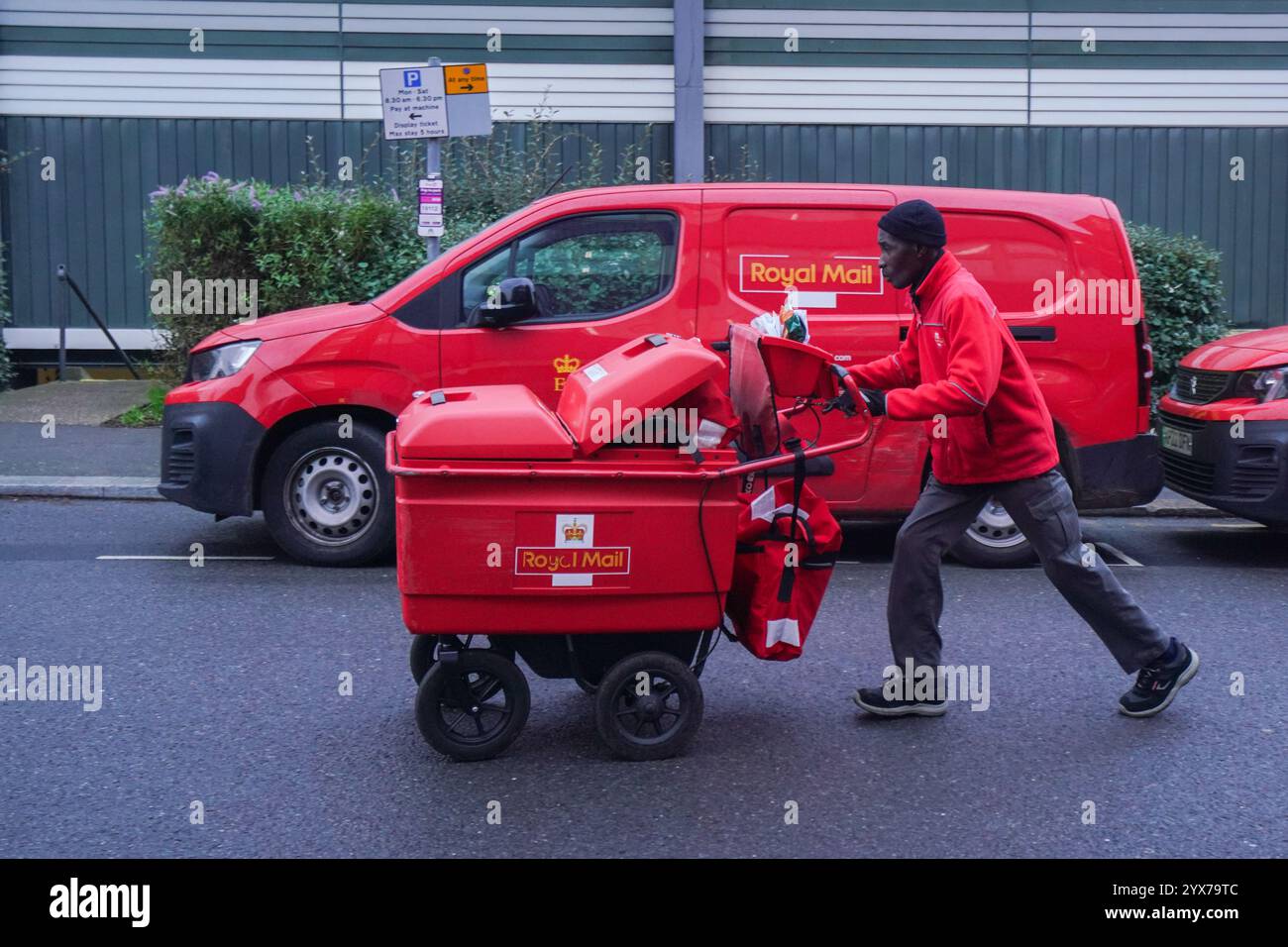 London, UK. 14 December 2024 A postman making deliveries outside the ...