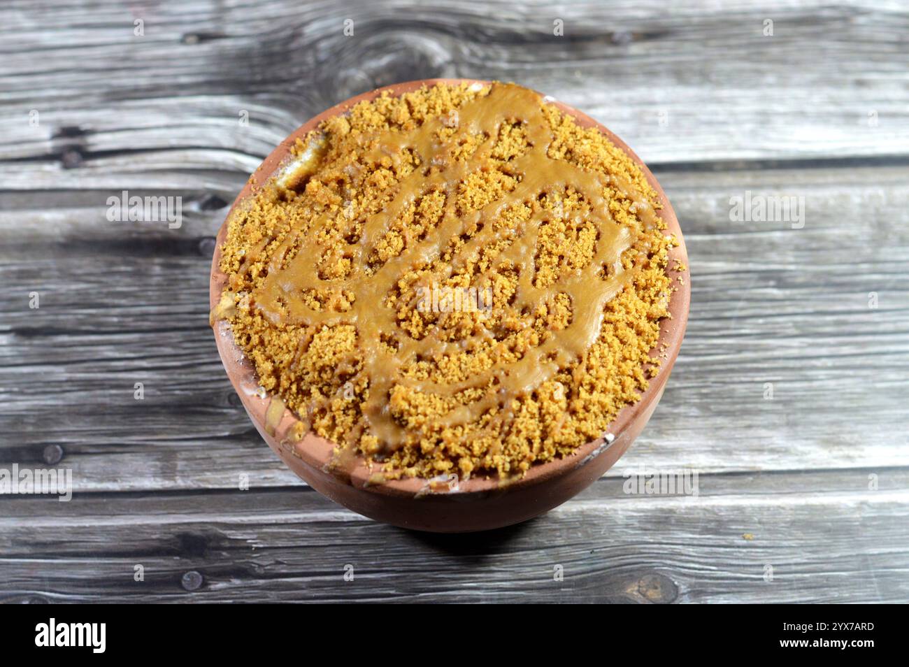 Egyptian bread pudding topped with biscuits butter spread, milk in bowl ...