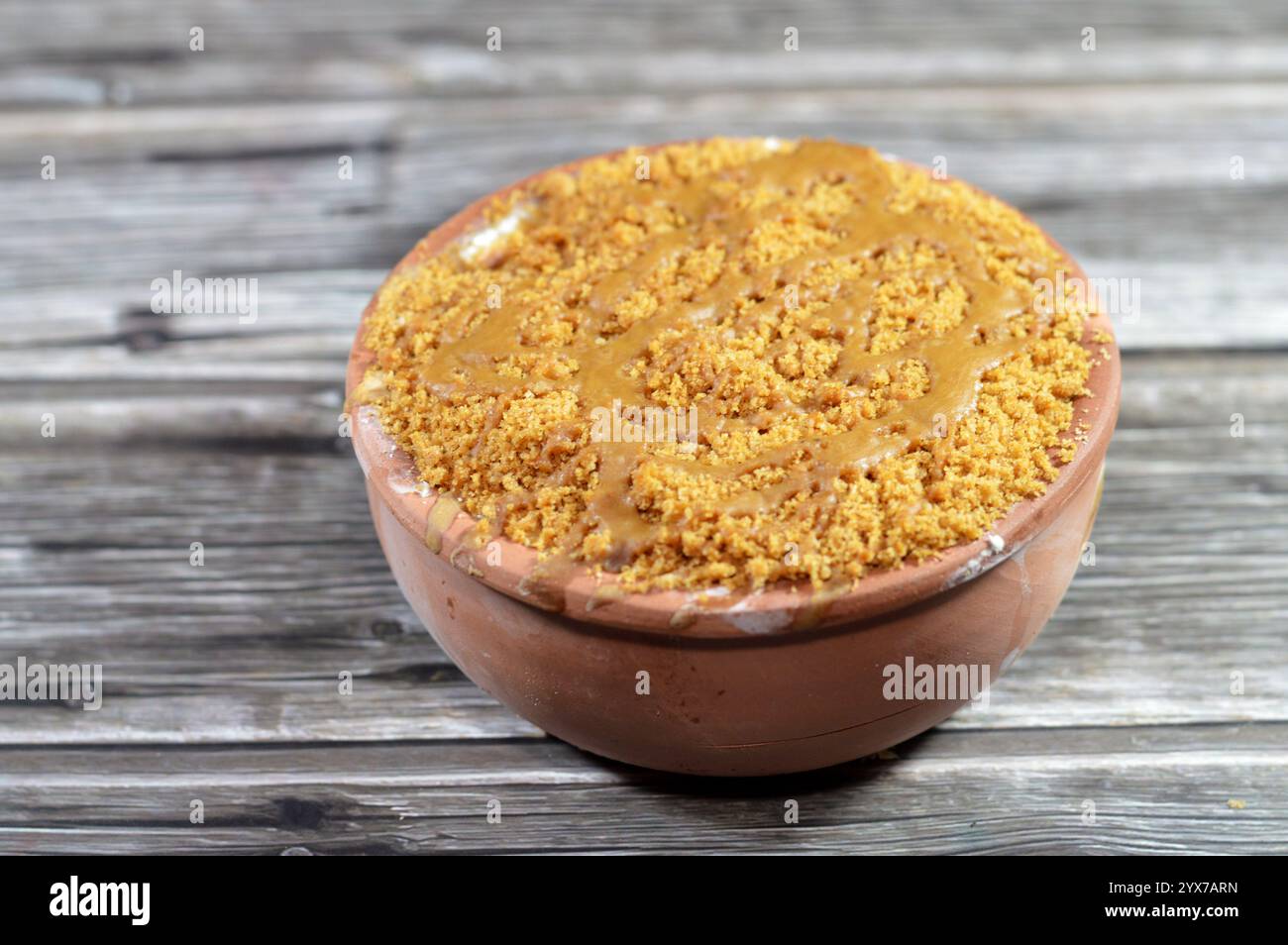 Egyptian bread pudding topped with biscuits butter spread, milk in bowl ...