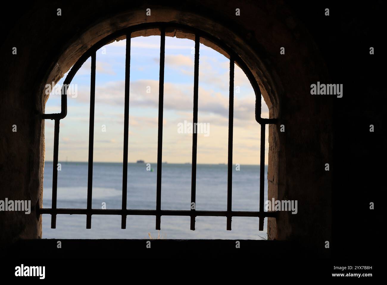 A barred window arch. Cast iron bars in an arched window, overlooking a ...
