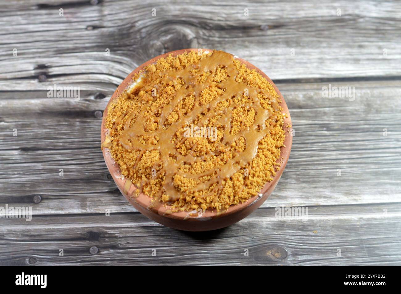 Egyptian bread pudding topped with biscuits butter spread, milk in bowl ...