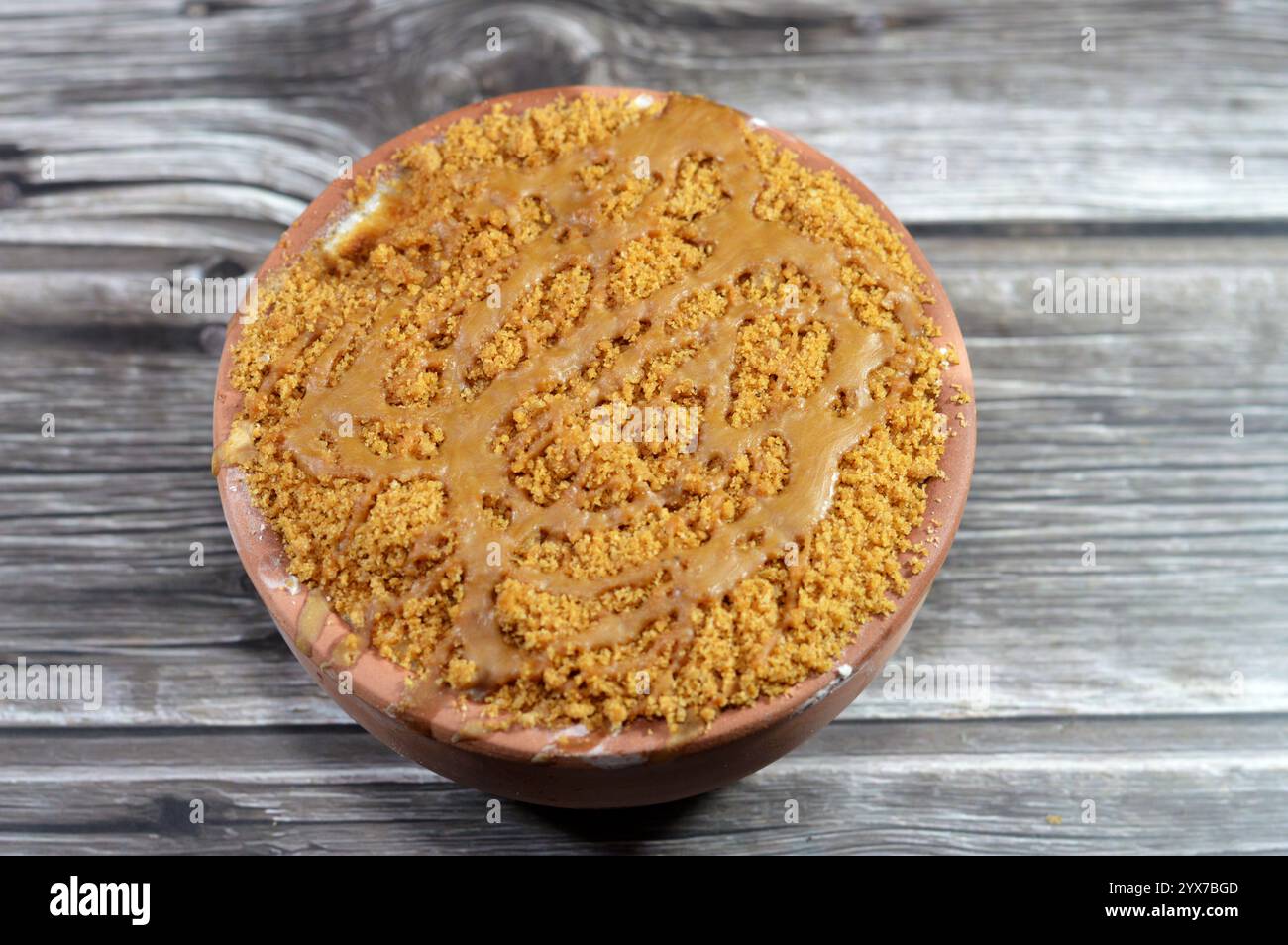 Egyptian bread pudding topped with biscuits butter spread, milk in bowl ...