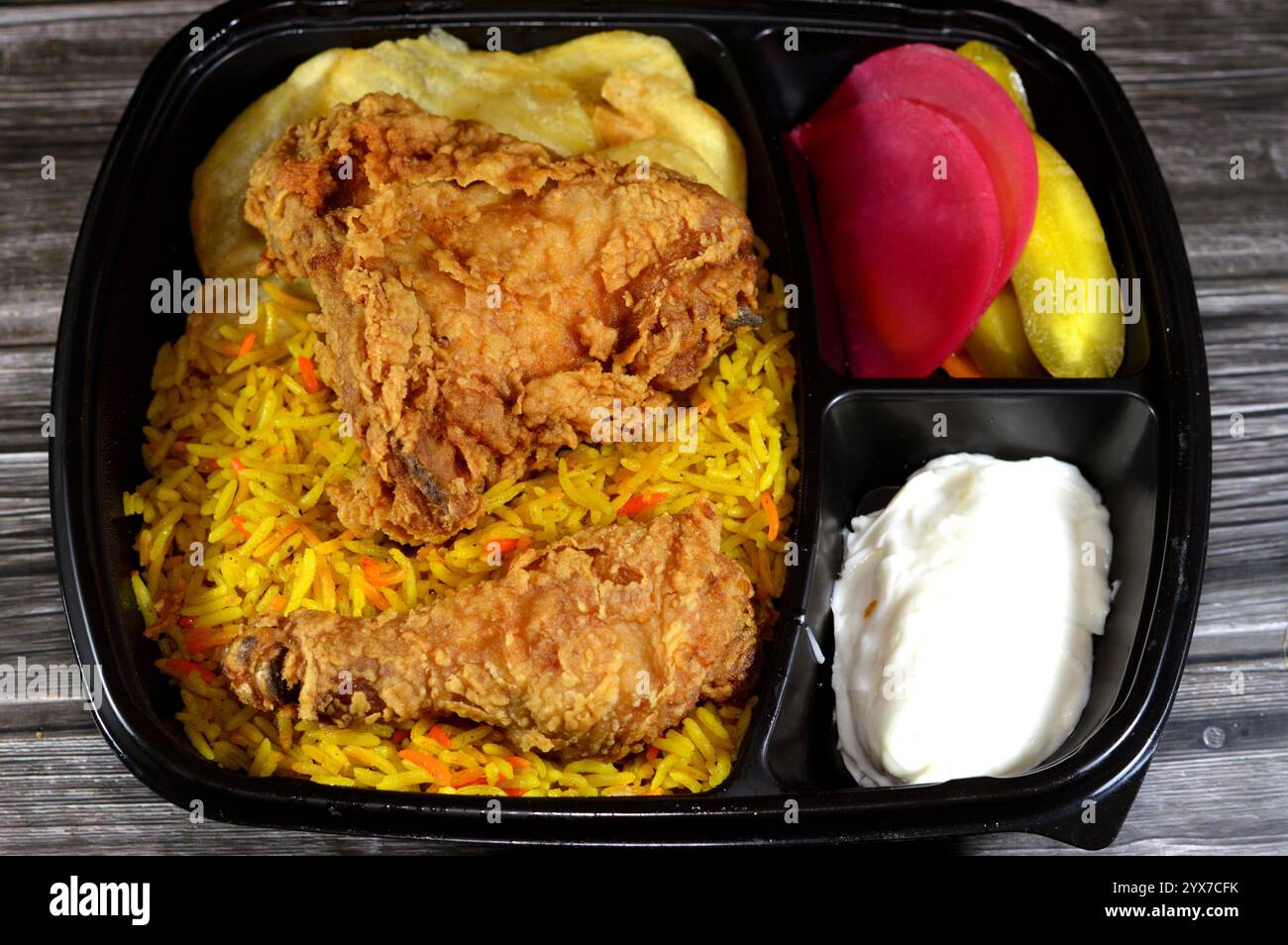 Broasted chicken meal with colorful Basmati rice, pickled slices of ...