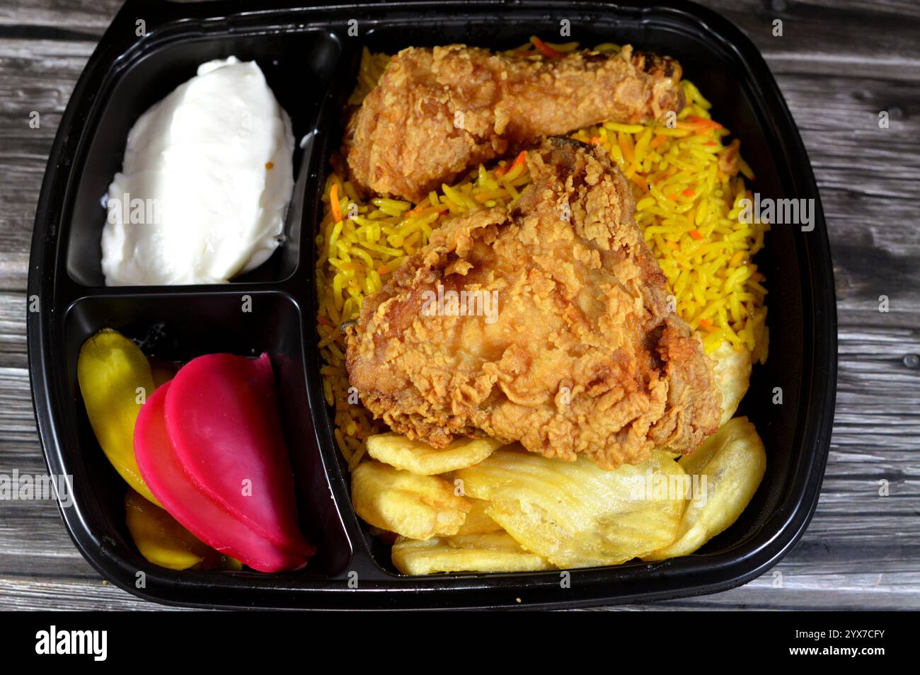 Broasted chicken meal with colorful Basmati rice, pickled slices of ...