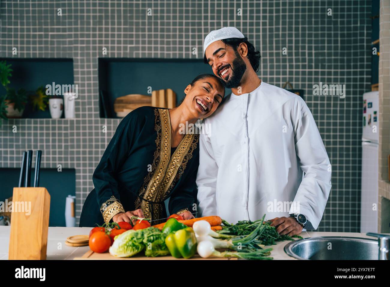 Happy beautiful young arab couple with emirati clothing together at home - Middle-eastern man ...