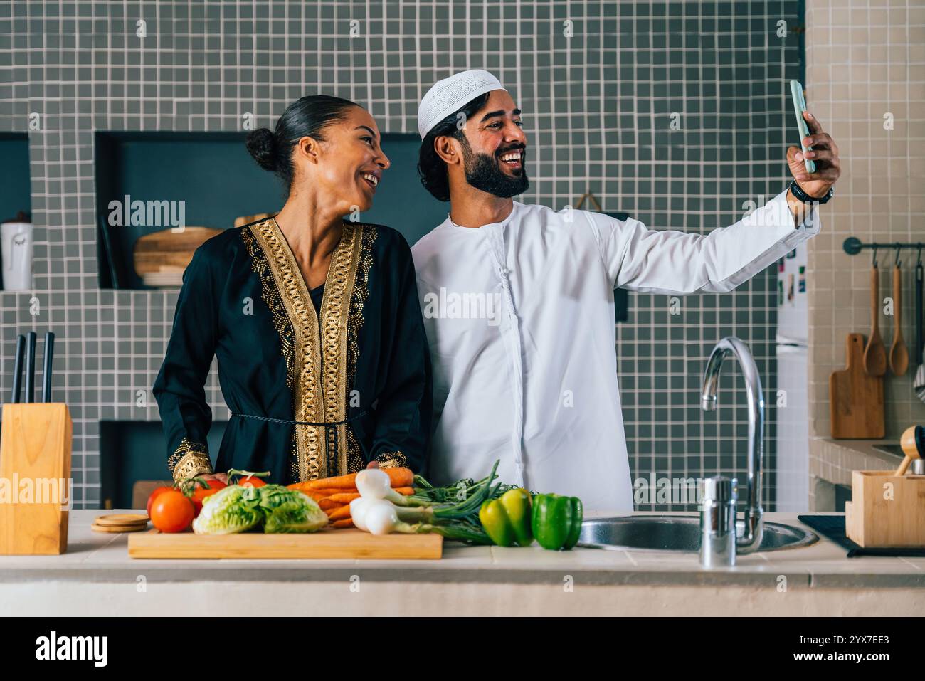 Happy beautiful young arab couple with emirati clothing together at home - Middle-eastern man ...