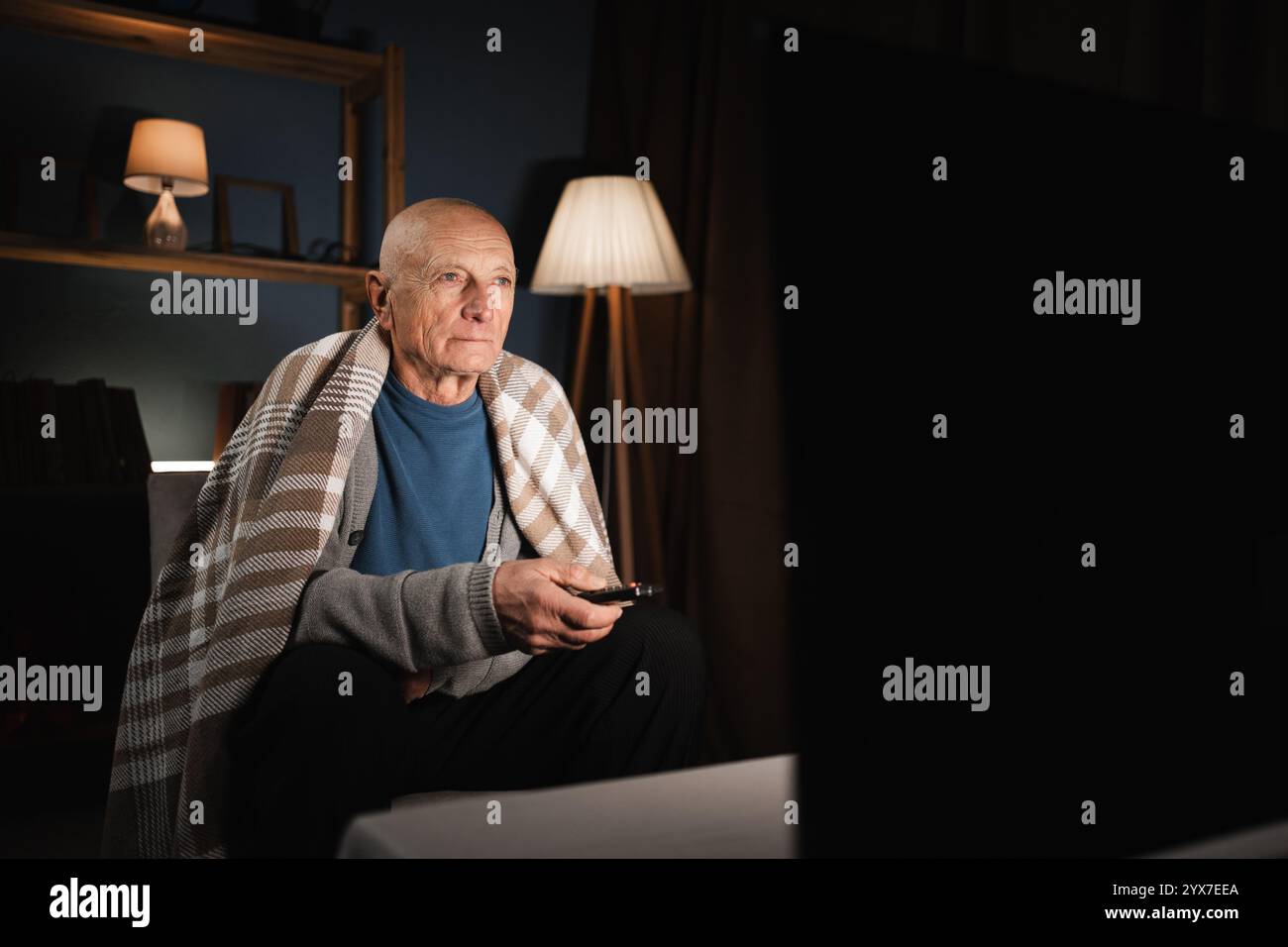 Elderly man sitting in armchair watching tv and changing channels with ... Elderly man sitting in armchair watching tv and changing channels with ...