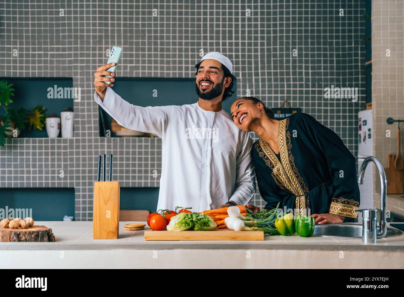 Happy beautiful young arab couple with emirati clothing together at home - Middle-eastern man ...