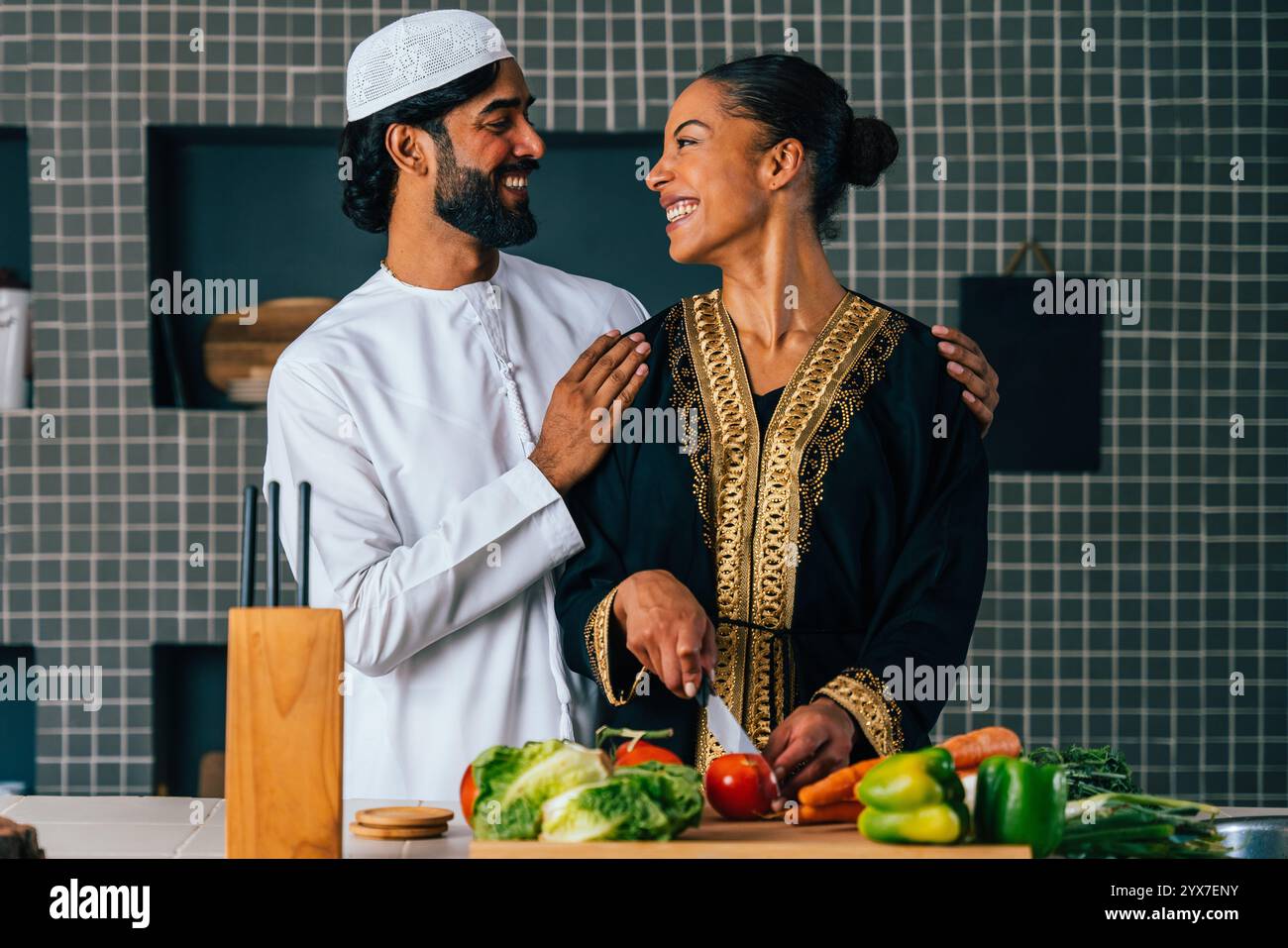Happy beautiful young arab couple with emirati clothing together at home - Middle-eastern man ...