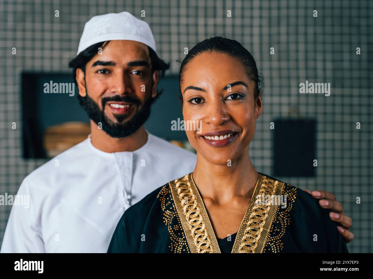 Happy beautiful young arab couple with emirati clothing together at home - Middle-eastern man ...