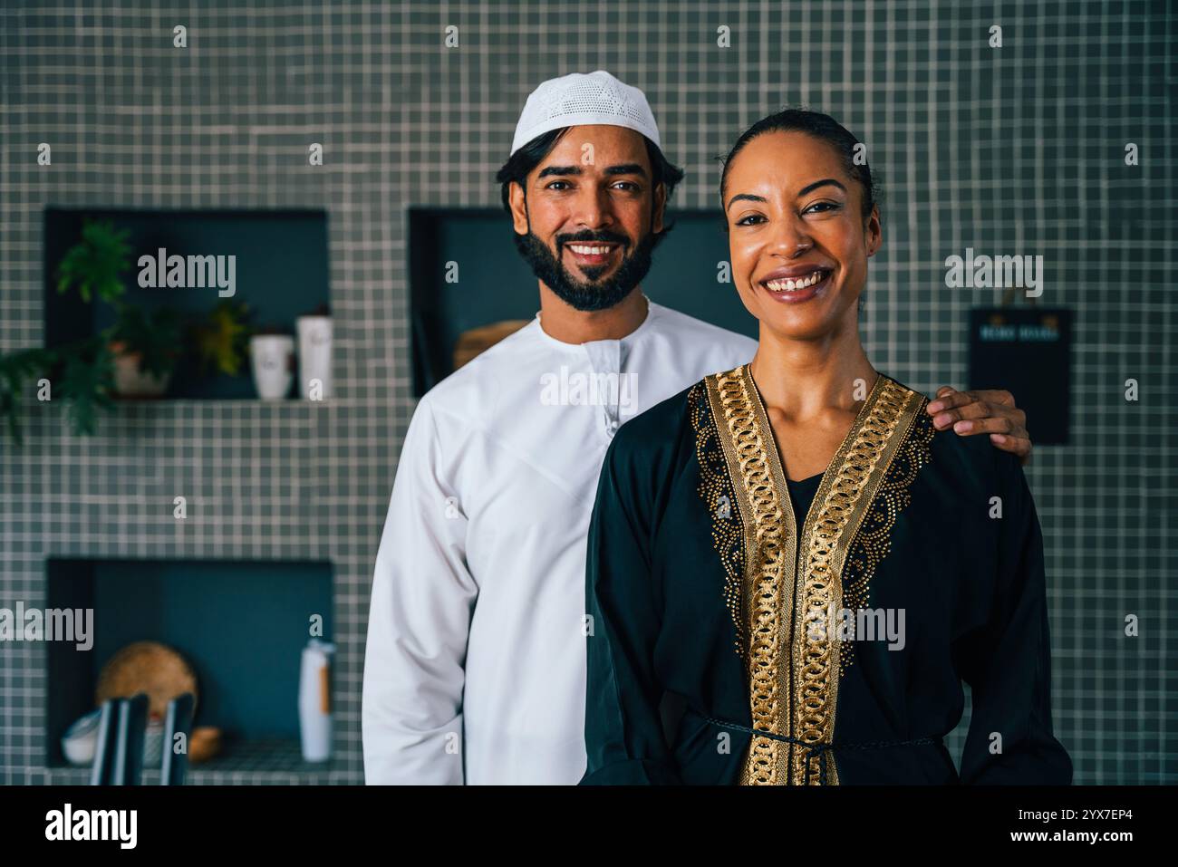Happy beautiful young arab couple with emirati clothing together at home - Middle-eastern man ...
