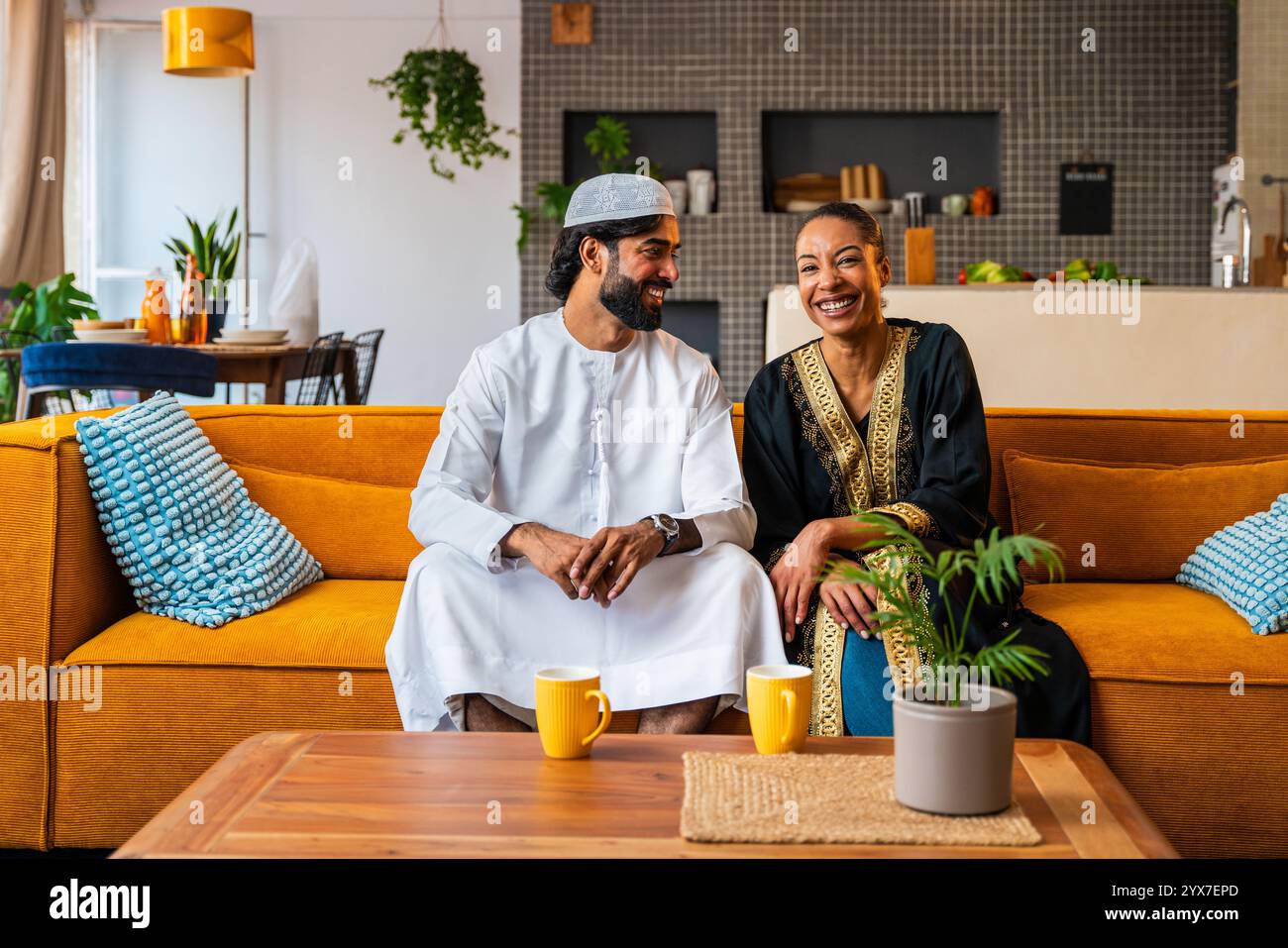 Happy beautiful young arab couple with emirati clothing together at home - Middle-eastern man ...
