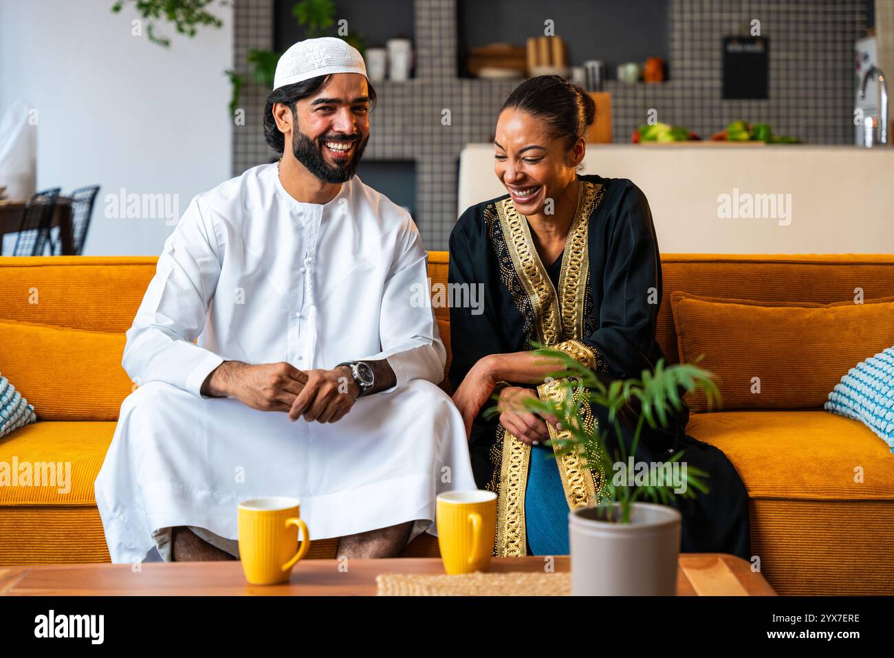 Happy beautiful young arab couple with emirati clothing together at home - Middle-eastern man ...