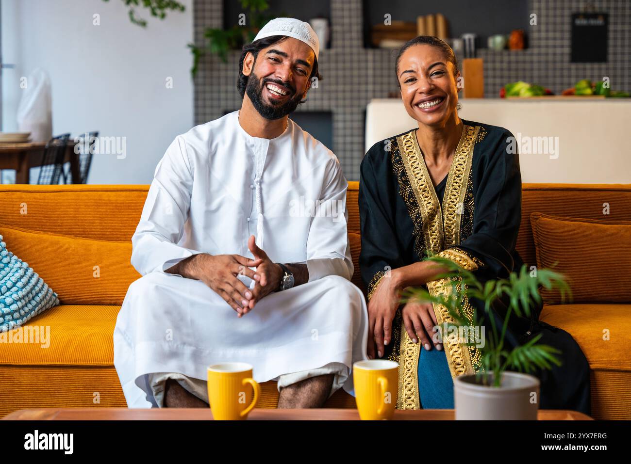 Happy beautiful young arab couple with emirati clothing together at home - Middle-eastern man ...