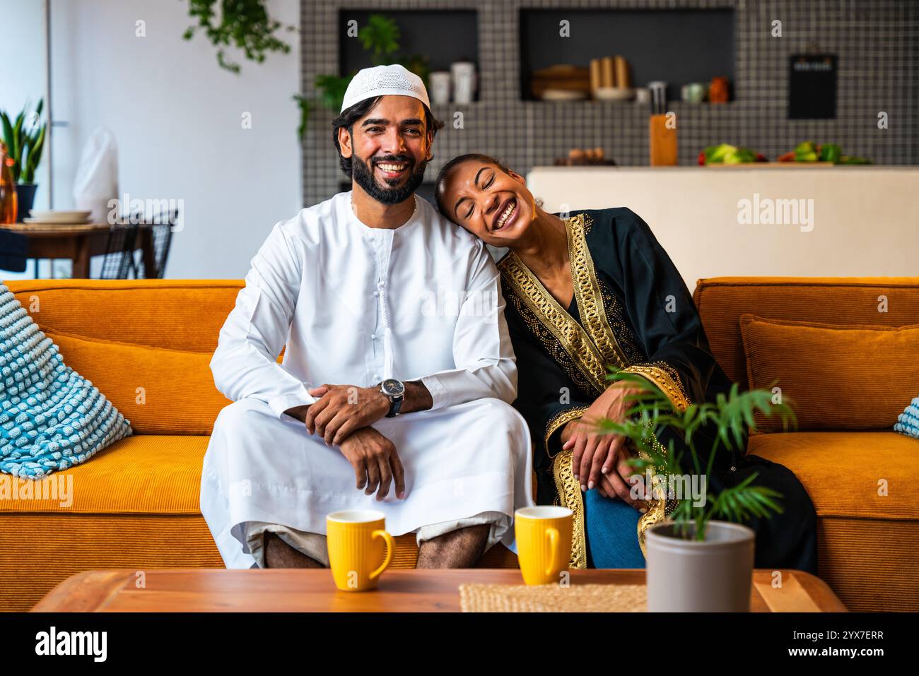Happy beautiful young arab couple with emirati clothing together at home - Middle-eastern man ...