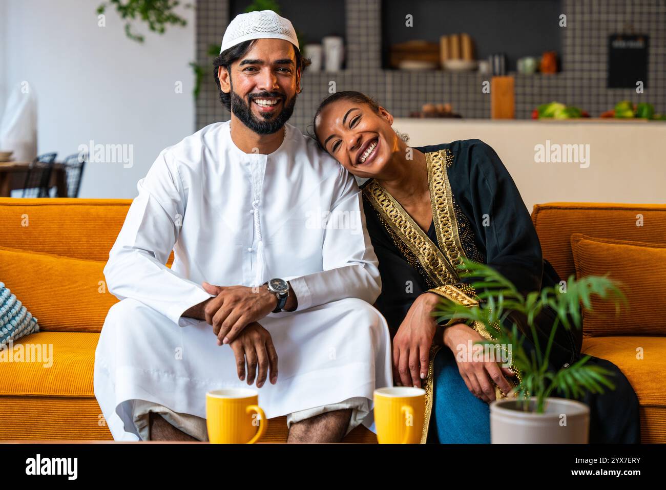 Happy beautiful young arab couple with emirati clothing together at home - Middle-eastern man ...