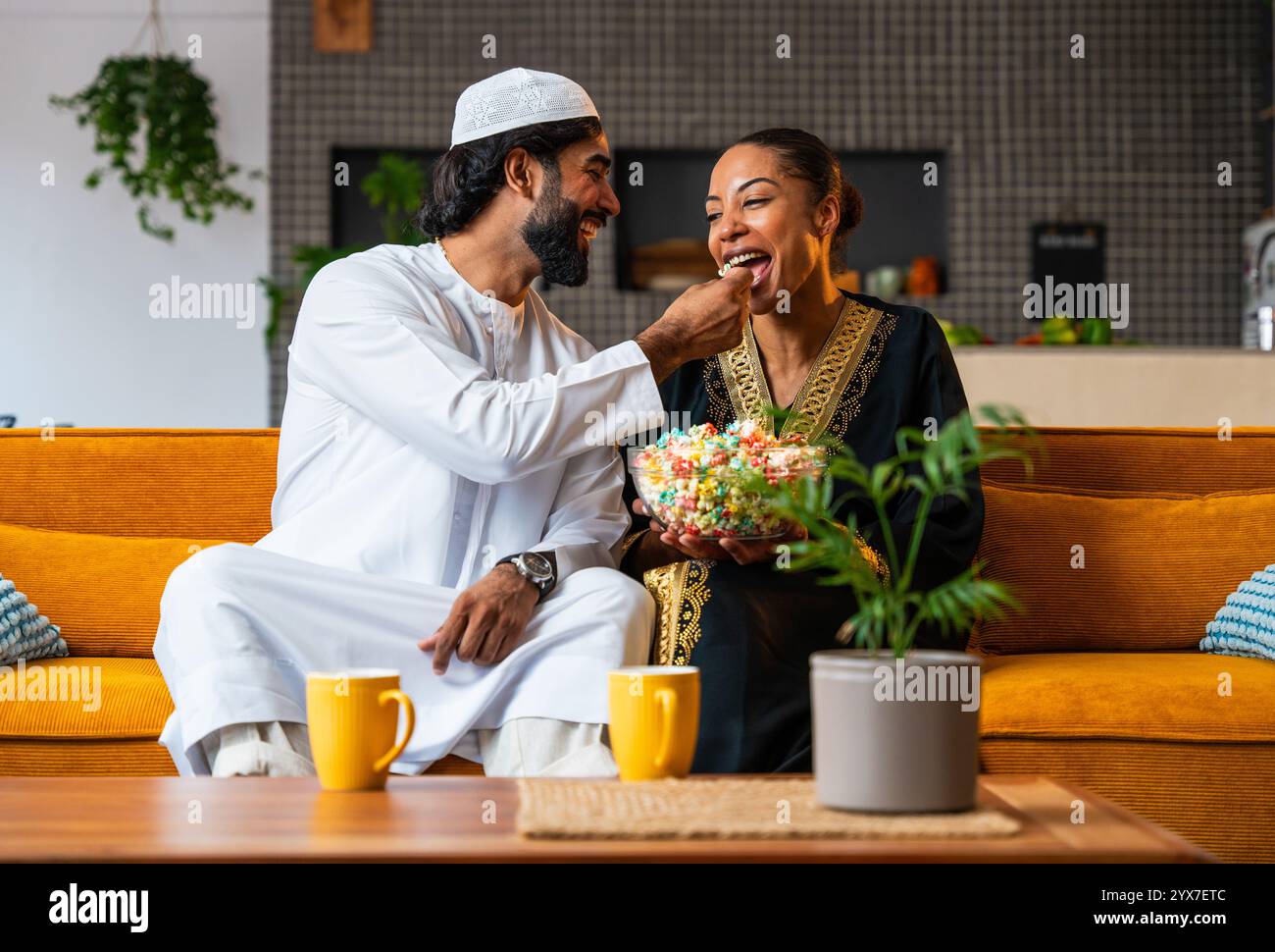 Happy beautiful young arab couple with emirati clothing together at home - Middle-eastern man ...