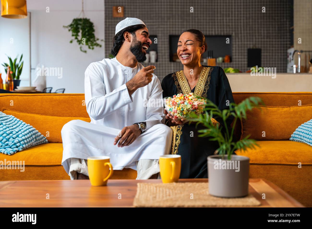 Happy beautiful young arab couple with emirati clothing together at home - Middle-eastern man ...