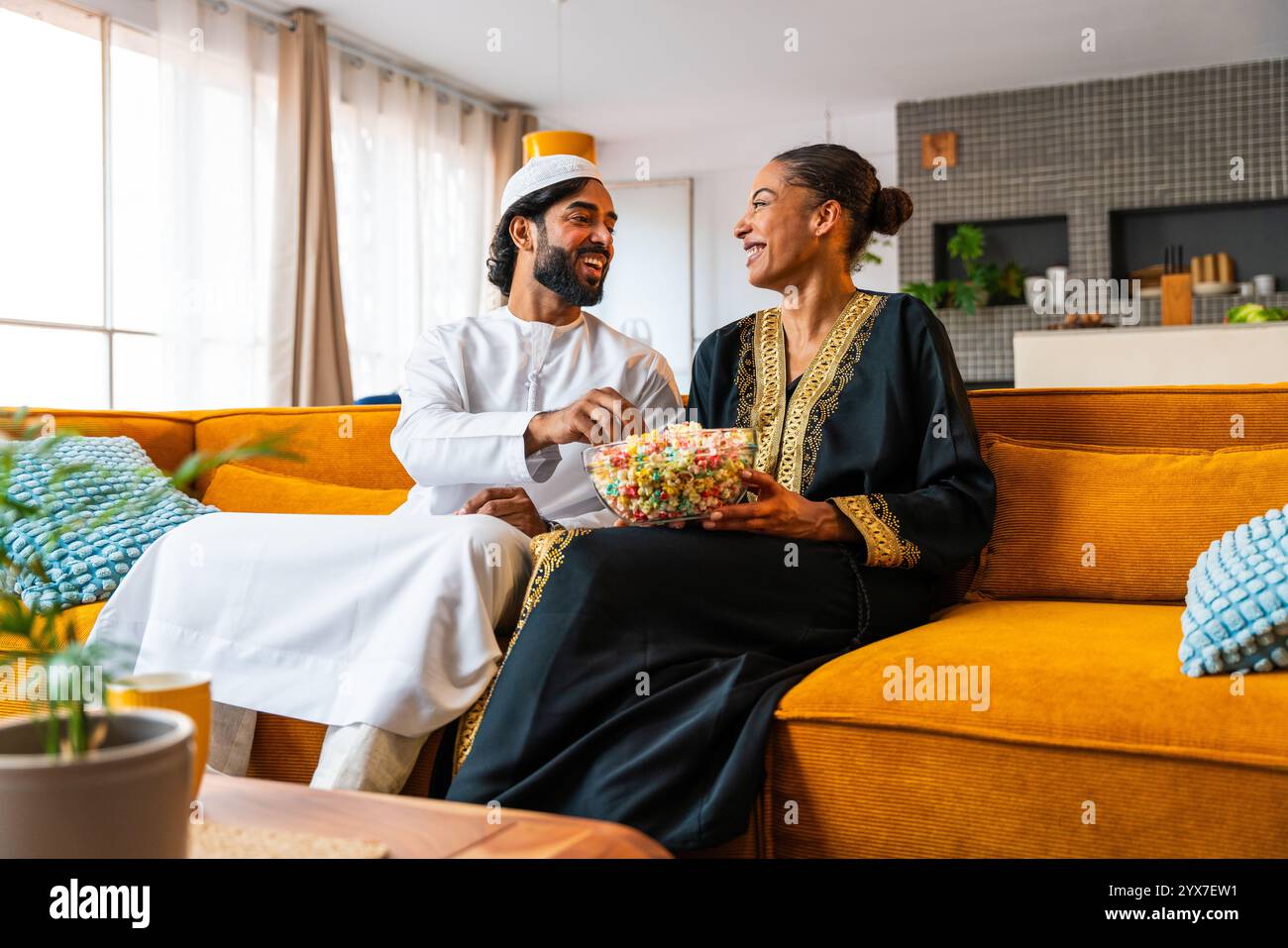 Happy beautiful young arab couple with emirati clothing together at home - Middle-eastern man ...