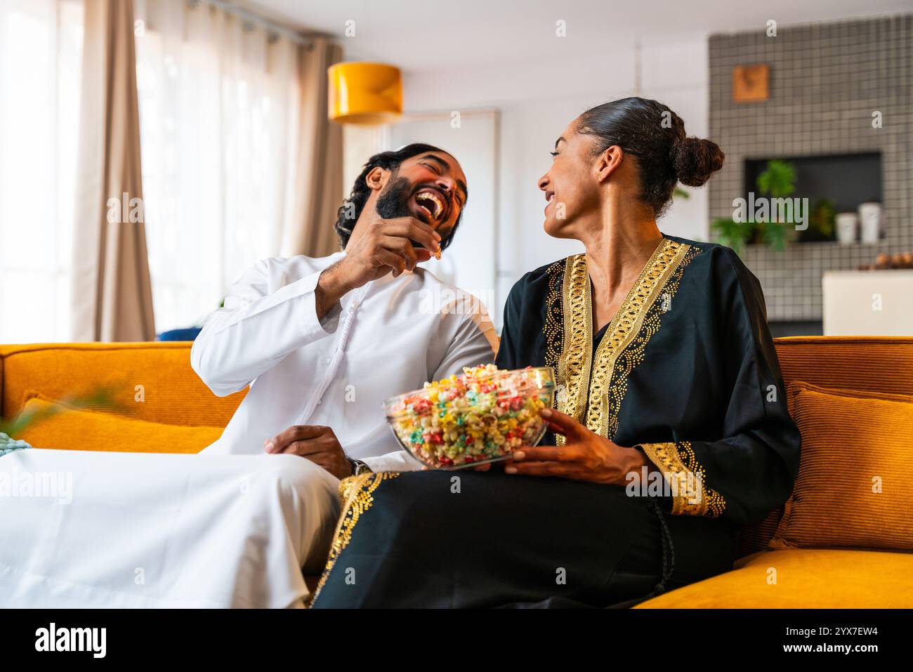 Happy beautiful young arab couple with emirati clothing together at home - Middle-eastern man ...