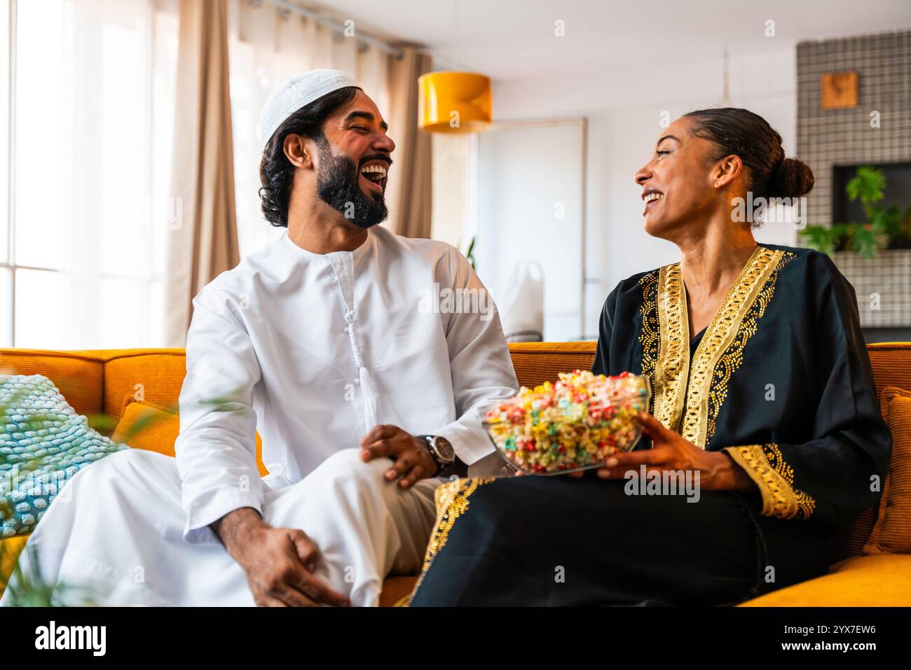 Happy beautiful young arab couple with emirati clothing together at home - Middle-eastern man ...